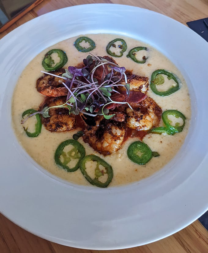 Shrimp and grits reimagined with artistic flair—those jalapeño rings create a spicy halo around perfectly seasoned seafood. Southern comfort meets Columbus creativity.