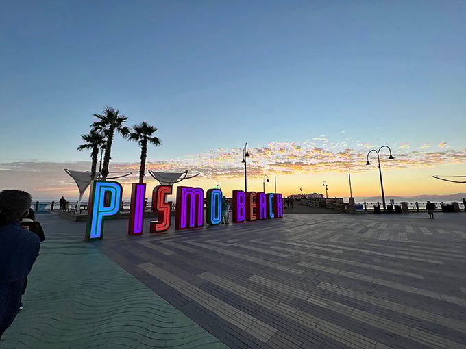 Pismo Beach's colorful sign glows at dusk, reminding shoppers there's more to life than bargains—though the bargains are pretty spectacular.