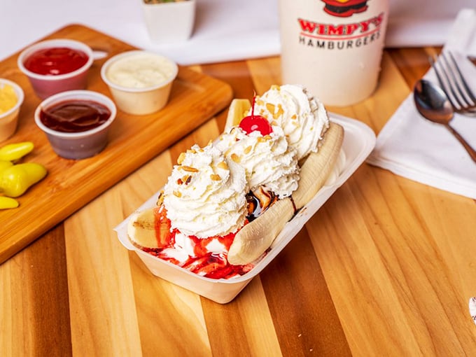 This banana split isn't just dessert – it's a childhood memory served in a boat with whipped cream mountains and cherry-topped nostalgia.