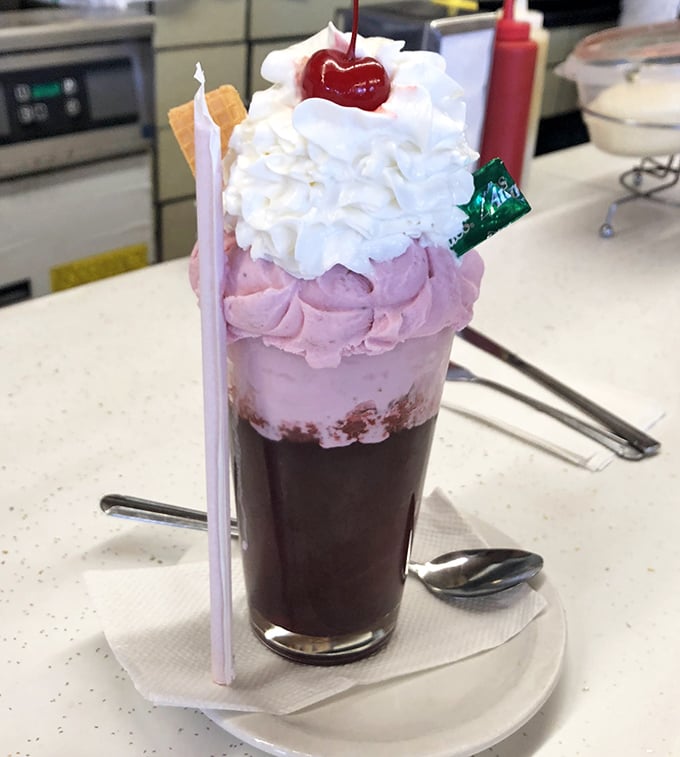 This isn't just a strawberry soda—it's a three-act play of ice cream, whipped cream, and cherry, with a straw standing by for the grand finale.