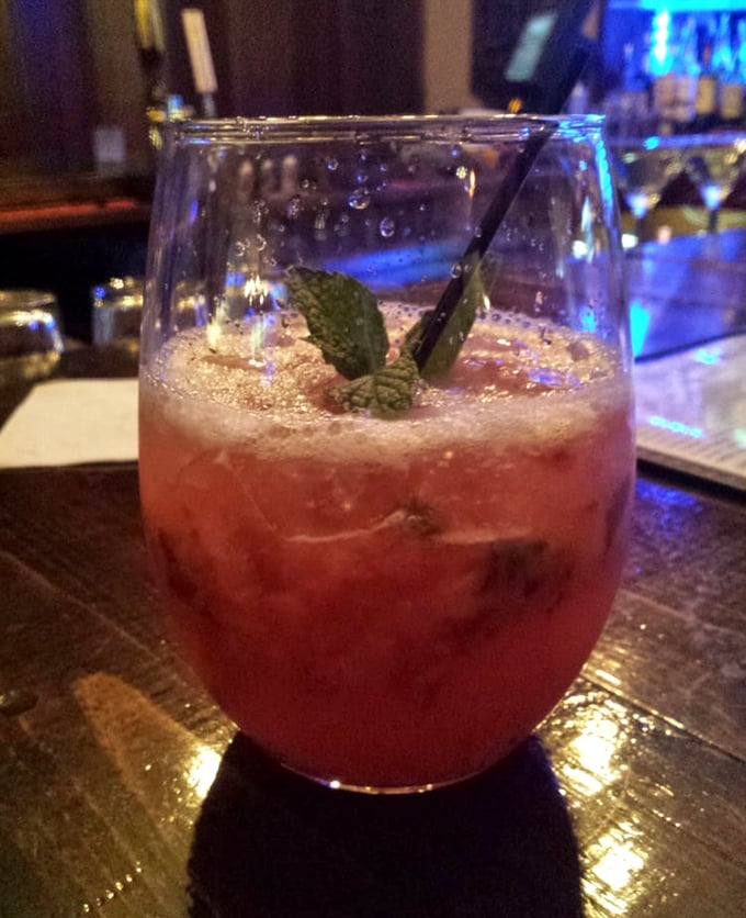 The kind of cocktail that makes you forget your troubles—a strawberry mojito garnished with fresh mint and vacation vibes.