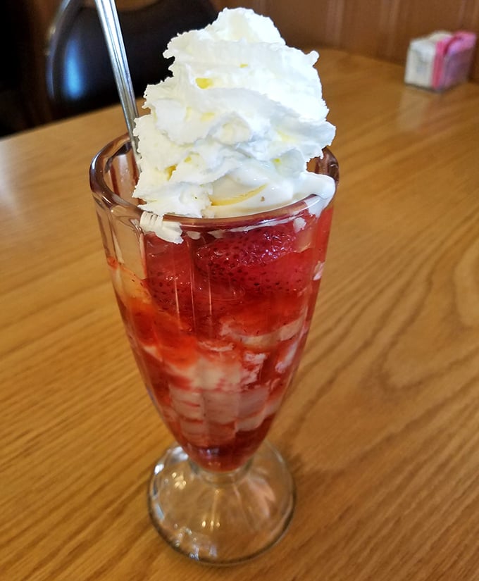 This strawberry sundae isn't trying to reinvent dessert—it's simply perfecting it. The whipped cream crown makes this glass goblet a throne for sweet satisfaction.