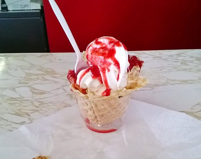 Ice cream and strawberry sauce performing their timeless duet in a waffle cone amphitheater. Some desserts don't need reinvention—just appreciation.