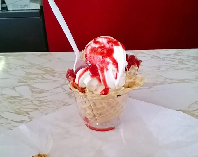 Ice cream and strawberry sauce performing their timeless duet in a waffle cone amphitheater. Some desserts don't need reinvention—just appreciation.