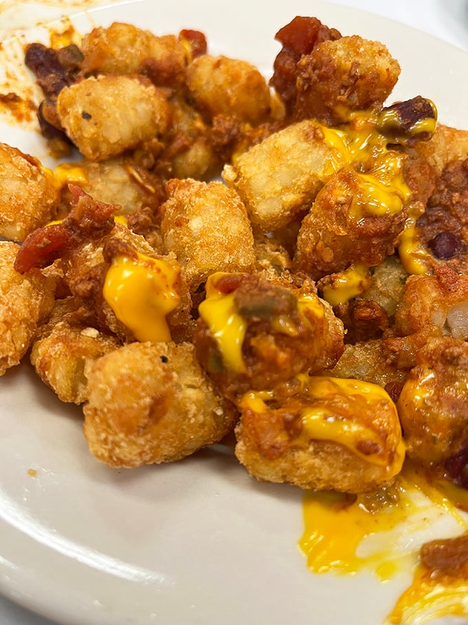 Cheese-covered tater tots that make you question why anyone would ever choose a side salad when this golden, crispy alternative exists.