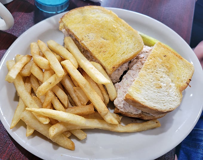 The humble tuna melt, elevated to art form. Golden-toasted bread embracing creamy tuna salad and melted cheese—comfort food that hugs you from the inside out.