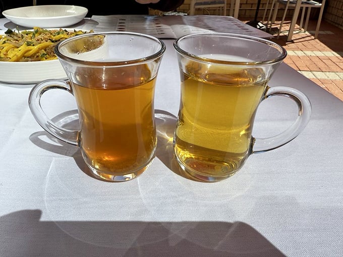 Two varieties of traditional tea—one amber, one golden—offer the perfect companions to cut through rich flavors and cleanse the palate between bites.