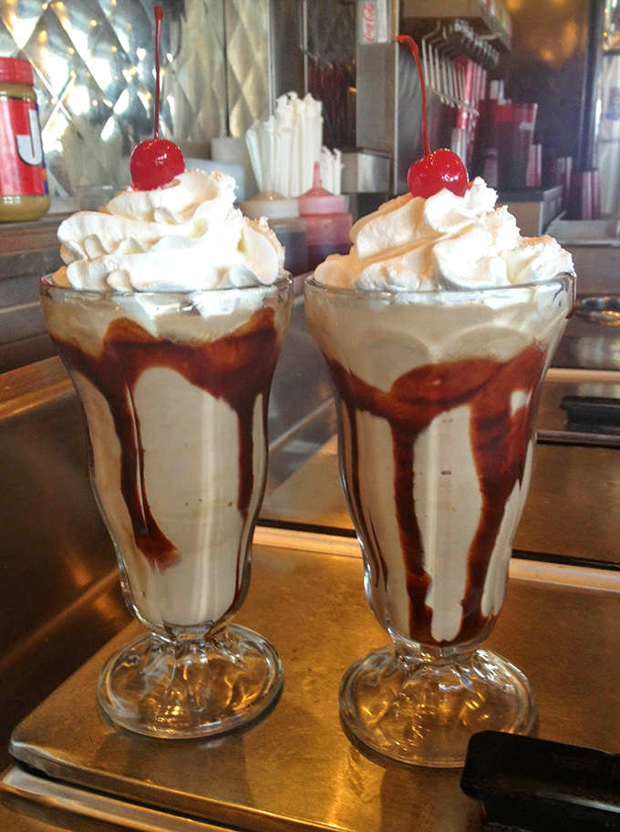 These milkshakes aren't just dessert—they're architecture, engineering, and art, topped with whipped cream mountains and cherry beacons.