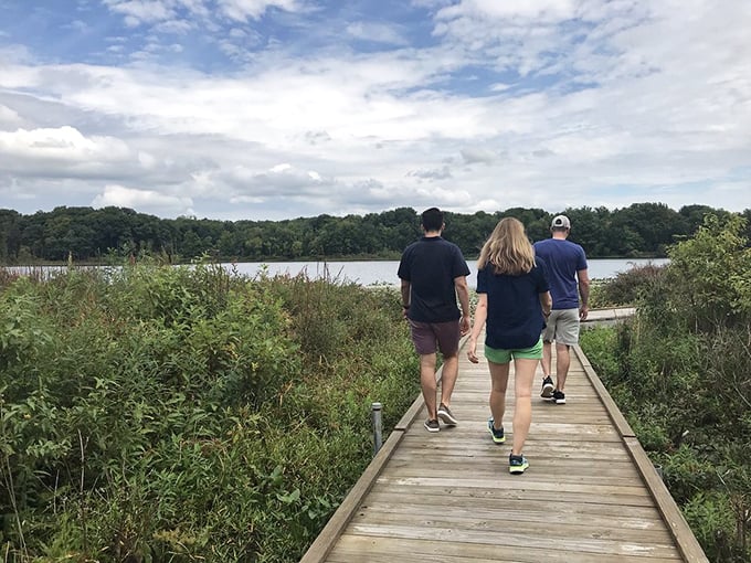 Three explorers following the wooden path toward discovery – sometimes the best conversations happen while walking side by side.