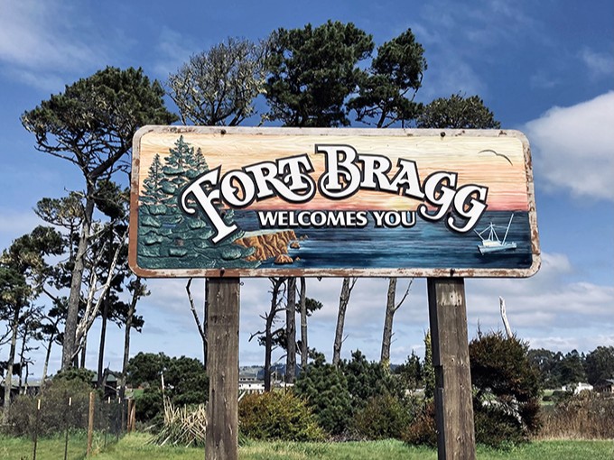The welcome sign says it all—trees, ocean, and hospitality—Fort Bragg's holy trinity wrapped up in weathered wood and coastal artwork.