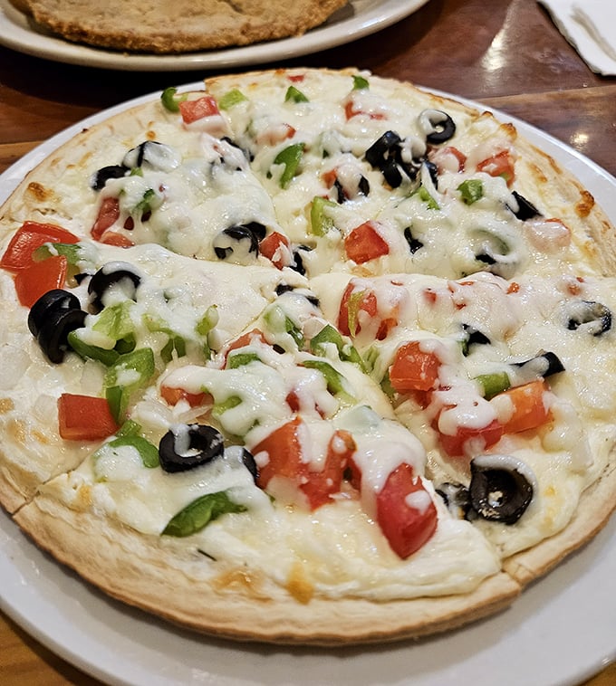 A veggie pizza that proves simplicity reigns supreme – fresh toppings on a canvas of melted cheese that would make an Italian grandmother nod in approval.