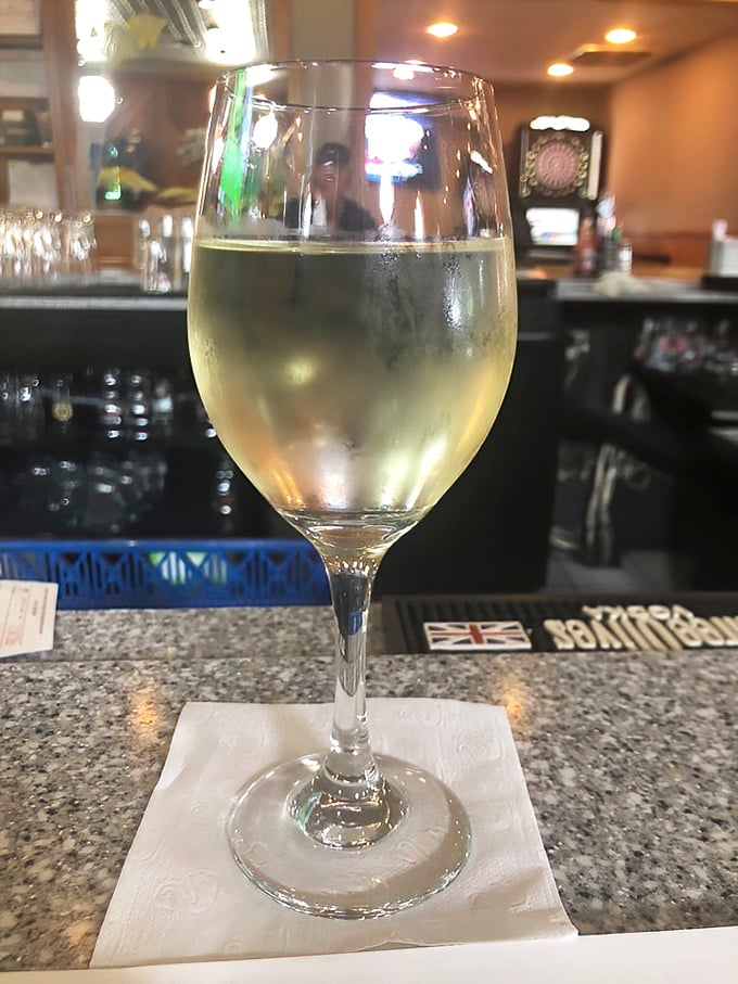 A glass of chilled white wine waits patiently at the bar, knowing it's about to meet its destiny alongside something spectacular from the sea.