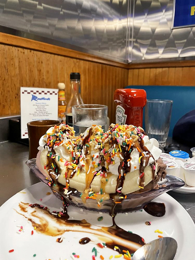 A banana split that laughs in the face of restraint—complete with enough whipped cream, sprinkles and sauces to make a dentist weep.