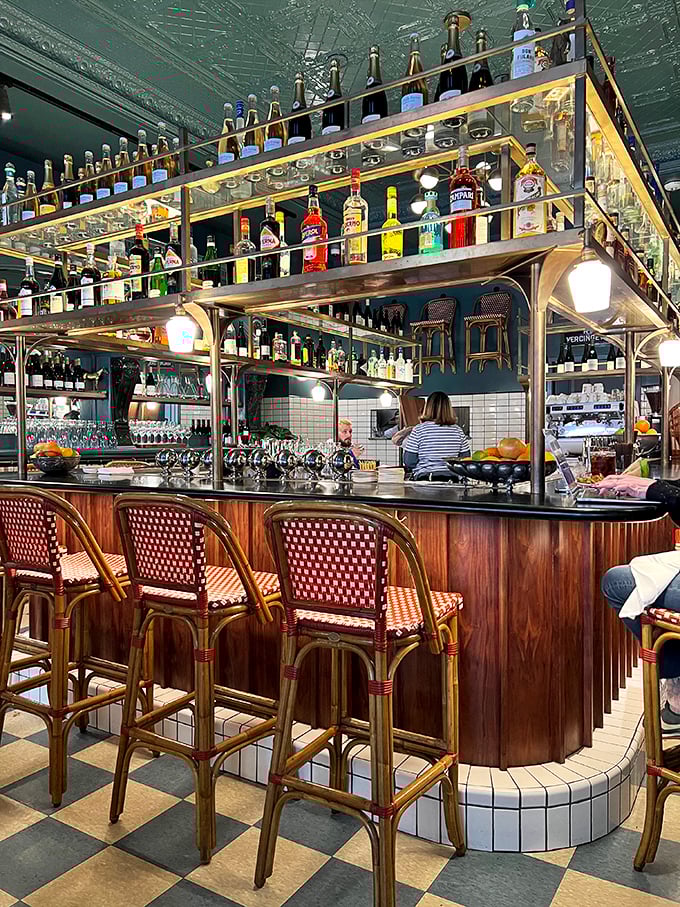 The bar area gleams with bottles like a liquid library of happiness. Those red bistro chairs aren't just seating—they're invitations to linger over one more perfectly crafted cocktail.