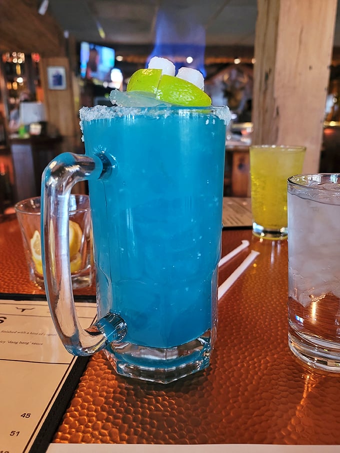 The Blue Lagoon cocktail—because sometimes your steak deserves a tropical vacation companion. Those lime wedges and marshmallows are having more fun than most people on spring break.