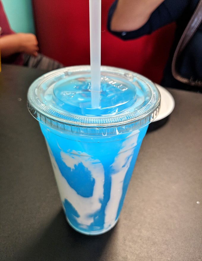 That blue swirl isn't just a drink—it's summer in a cup, the kind of vibrant concoction that makes adults remember what it felt like to be kids.