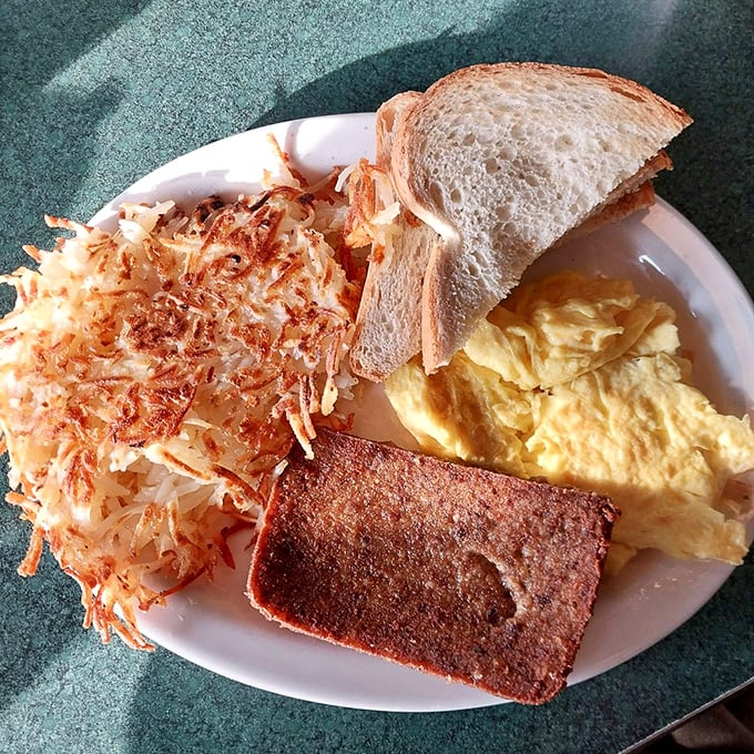 The breakfast trinity: perfectly scrambled eggs, crispy hash browns, and what appears to be scrapple—the holy grail of Pennsylvania breakfast meats.