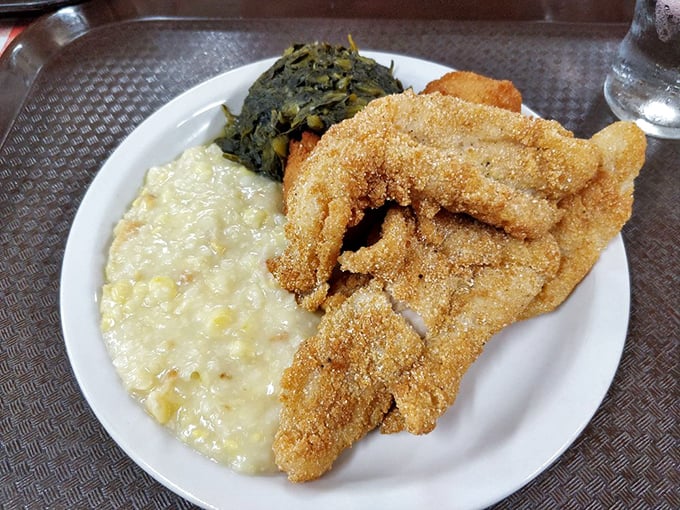 Cornmeal-crusted catfish with creamy mac and cheese and collard greens—a holy trinity of Southern comfort that demands reverence with every bite.