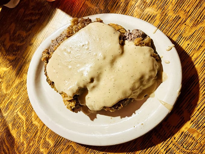 The chicken fried steak disappears under a blanket of peppery cream gravy—a dish that's less about looking pretty and more about pure, unadulterated pleasure.
