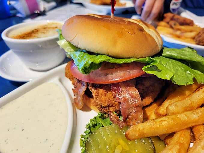 A sandwich that proves land and sea can coexist deliciously, stacked high enough to require a strategic approach to that first bite.