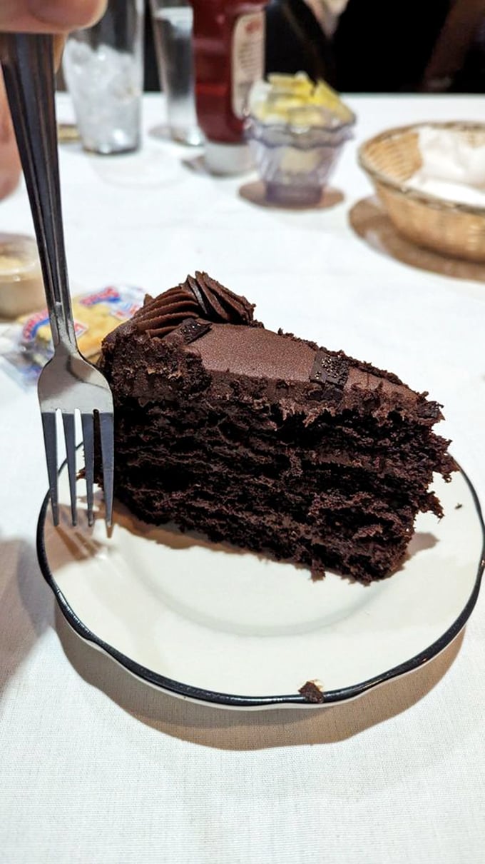 Chocolate cake so rich it probably has its own accountant. The fork is merely suggesting what we all know—resistance is futile.