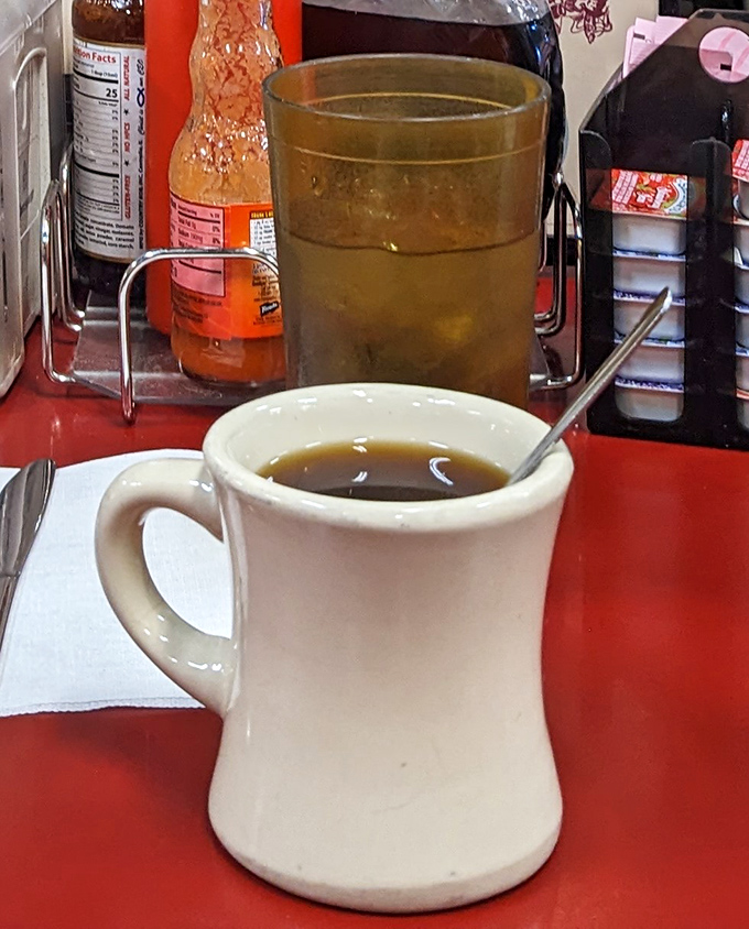 That sturdy white mug doesn't just hold coffee—it cradles liquid motivation in a vessel that's survived decades of morning conversations.
