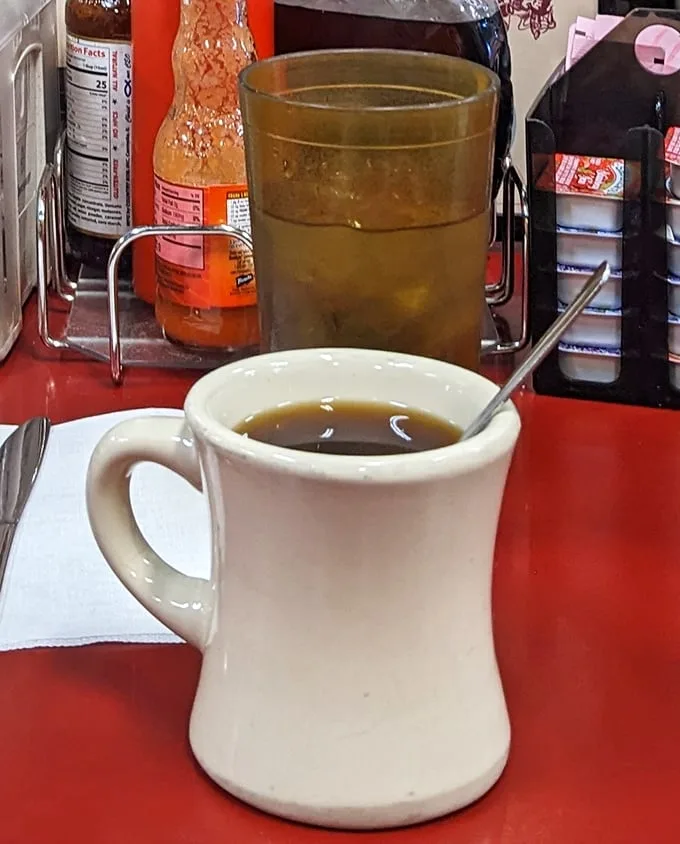 That sturdy white mug doesn't just hold coffee—it cradles liquid motivation in a vessel that's survived decades of morning conversations.