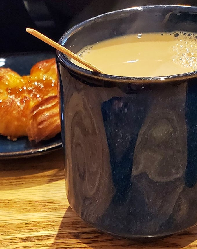 A proper ceramic mug of coffee alongside what appears to be a croissant—the breakfast combination that has launched a million productive mornings.