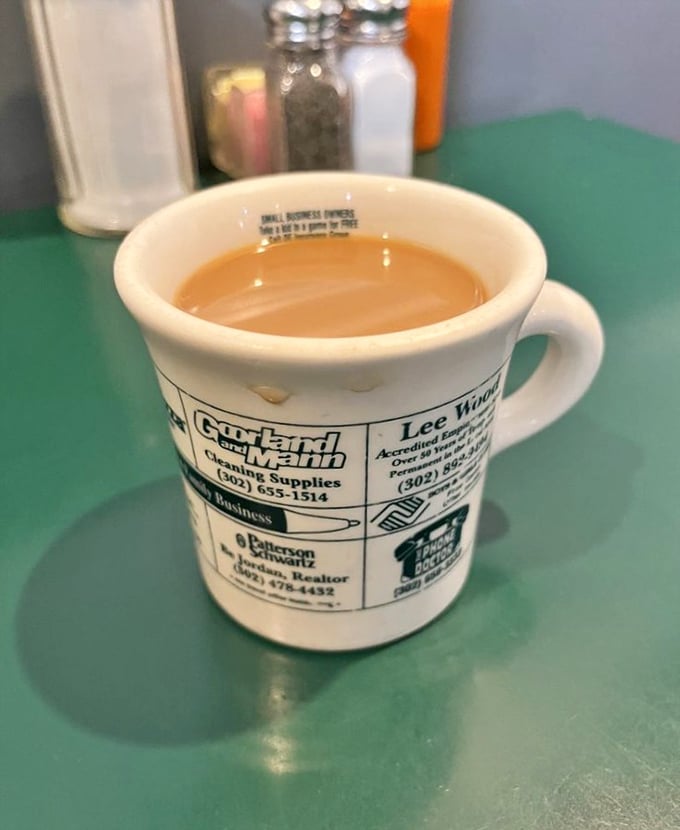 The coffee cup – adorned with local business ads – promises refills and conversation in equal measure.