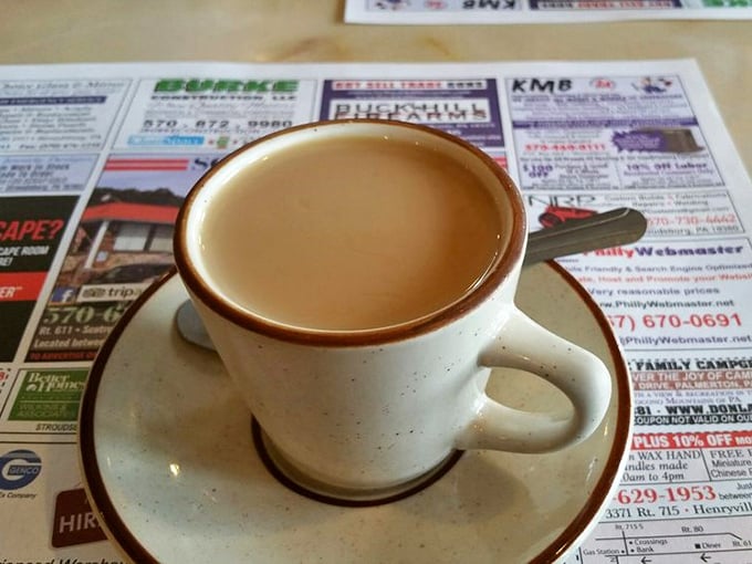 Coffee in a proper diner mug, resting on yesterday's news—a morning ritual as American as the pancakes it accompanies.