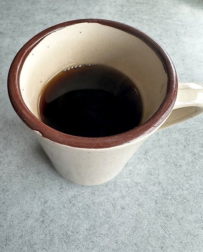 The humble diner coffee cup—containing what might be the fuel that powered America's greatest achievements, or at least its breakfast conversations.