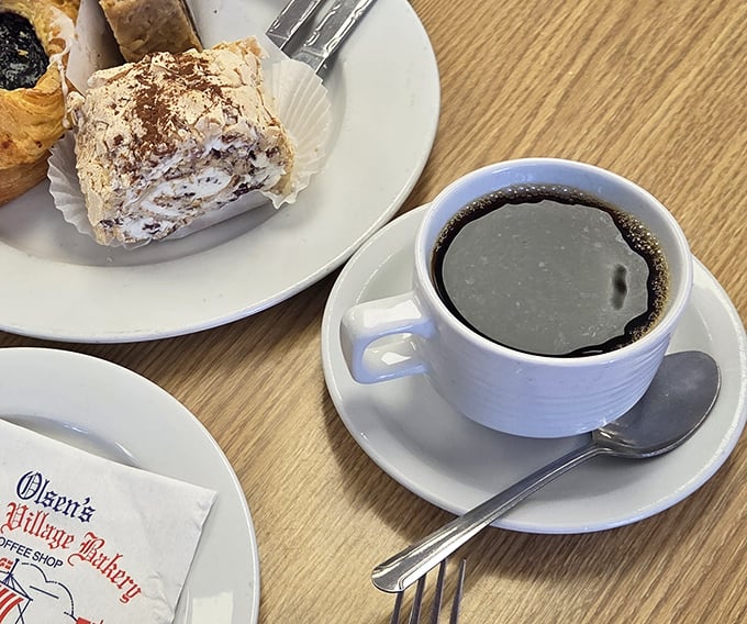 Coffee and pastry – a pairing as timeless as Bogart and Bacall, served on plates bearing the bakery's signature logo.