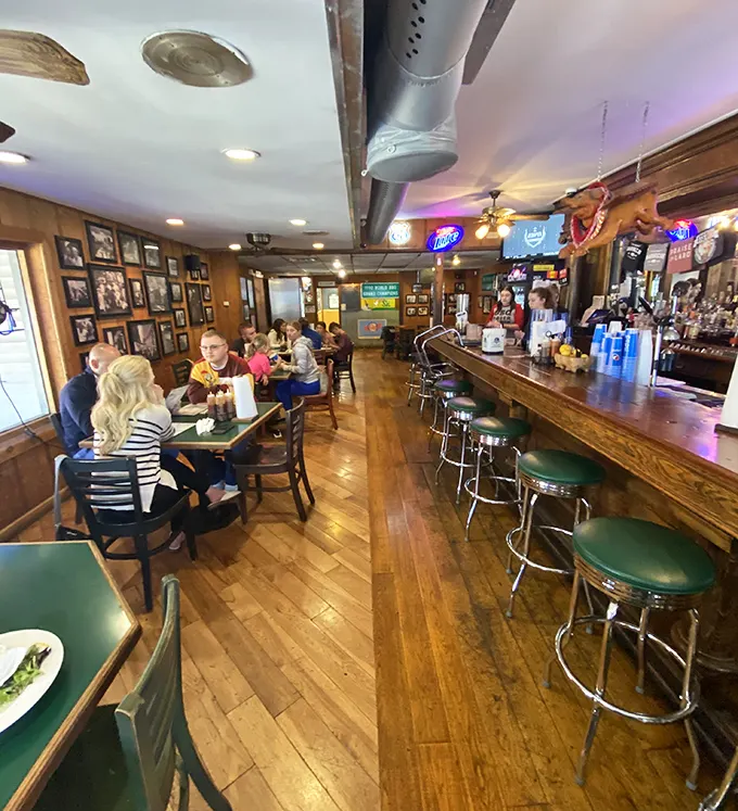 The bar area serves as mission control for BBQ operations, where cold drinks and warm conversations flow with equal abundance.