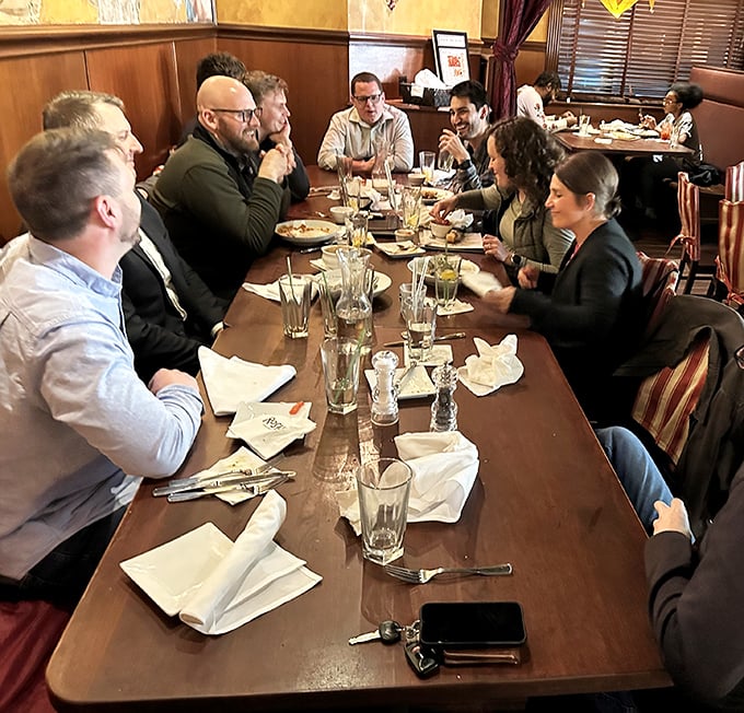 Good food brings people together. This long table of diners isn't just eating—they're creating memories that will outlast the meal itself.
