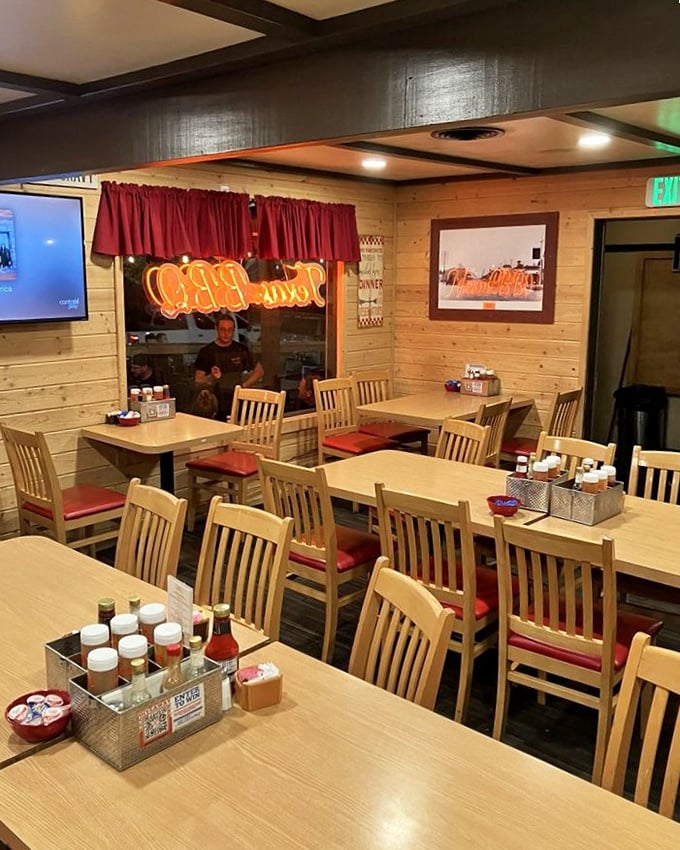 The dining room feels like grandma's kitchen got an upgrade – wood paneling, red cushions, and condiment caddies that have witnessed countless coffee refills.