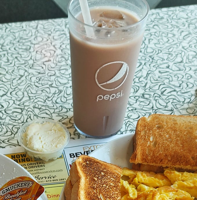 Chocolate milk in a Pepsi glass with a side of breakfast—proof that sometimes the best dining companions are simple pleasures.