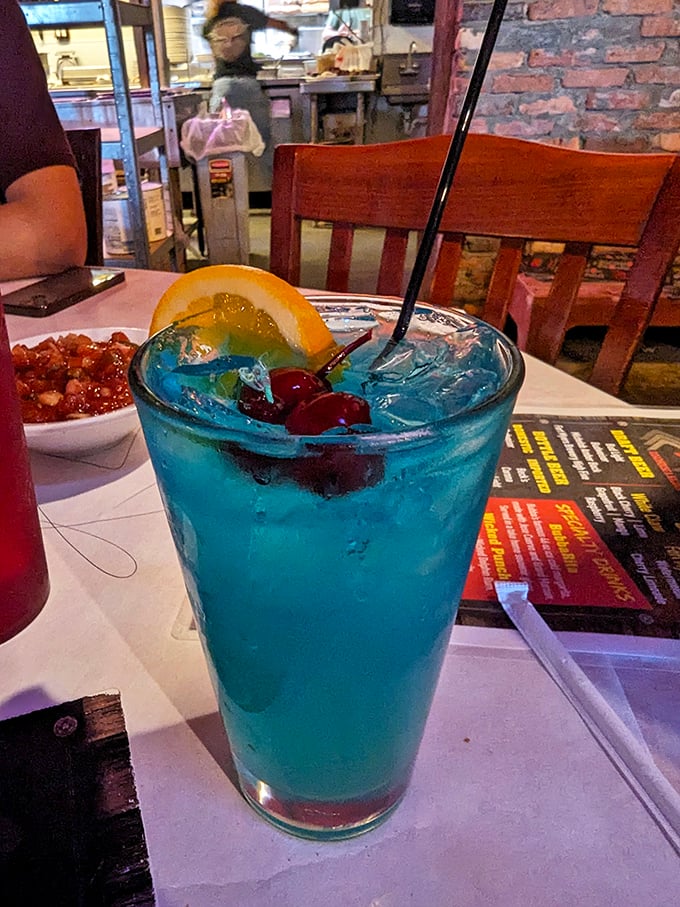 A blue cocktail that doesn't take itself too seriously, garnished with cherries and orange – because sometimes your drink should be as colorful as your vacation stories.