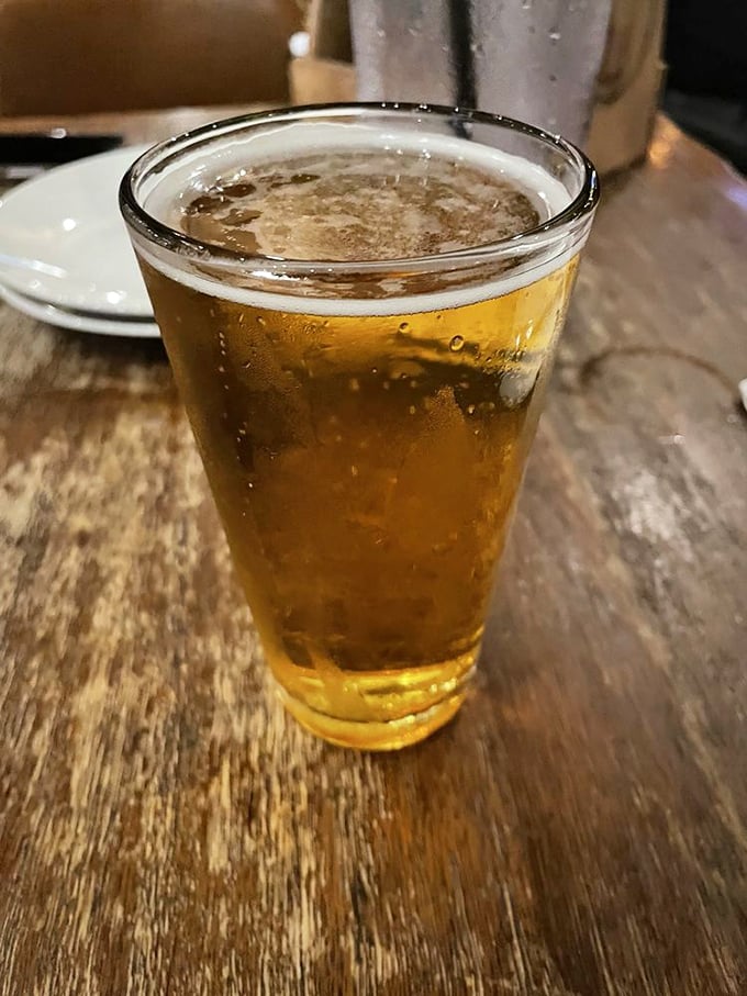 A cold beer on a wooden table—the perfect supporting actor in the barbecue drama unfolding on your plate. Simple pleasures, profound satisfaction.