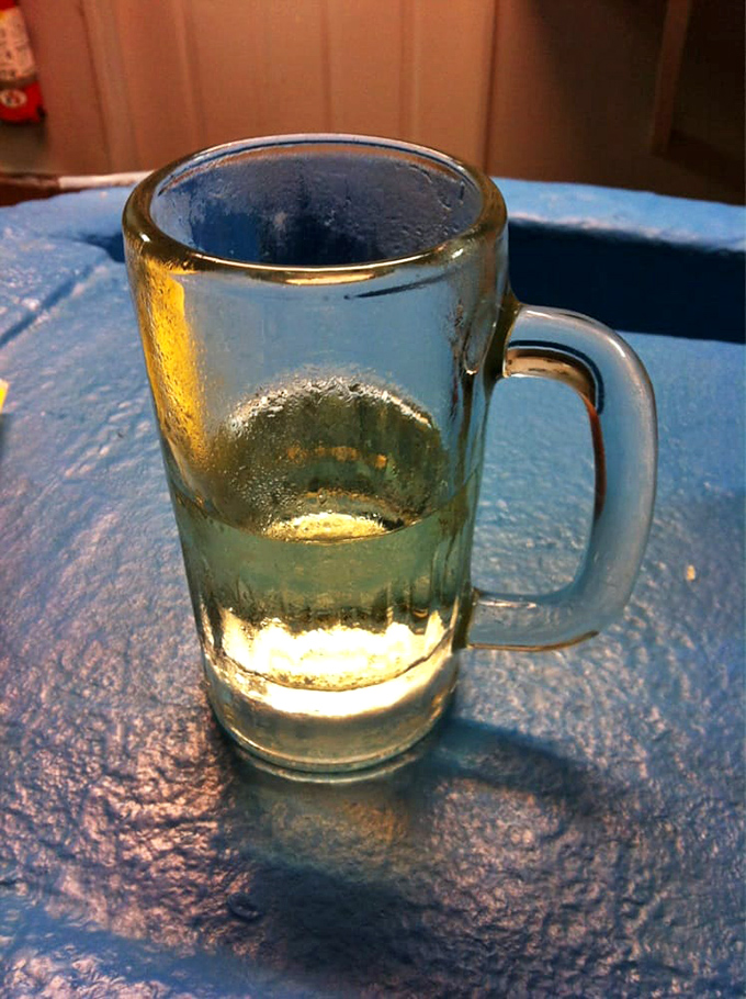 A nearly empty beer mug tells the story of a perfect pairing. Nothing complements briny oysters quite like an ice-cold brew in a frosty glass.