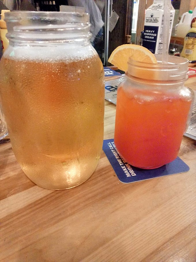 Mason jar beverages that bring back summer memories—one sweet tea and one sunset-colored concoction that promises refreshment with every sip.