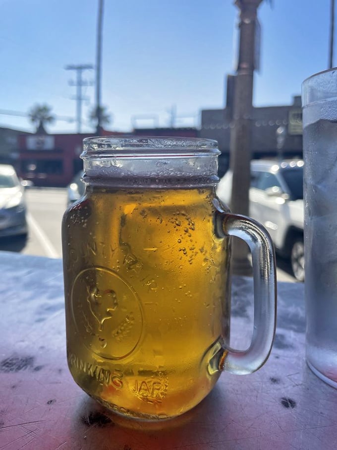 Beer served in a mason jar—because when you're eating a burger this good, your beverage deserves equally unpretentious presentation.
