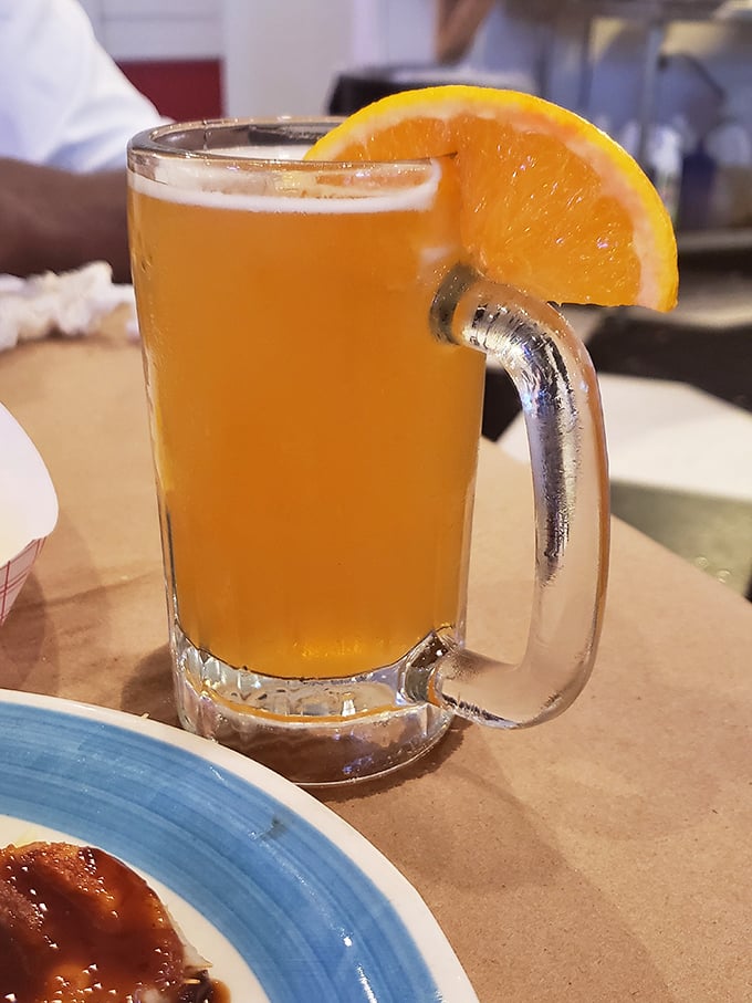 This beer, golden as a summer sunset and garnished with orange, isn't just a drink—it's liquid vacation in a frosty mug.