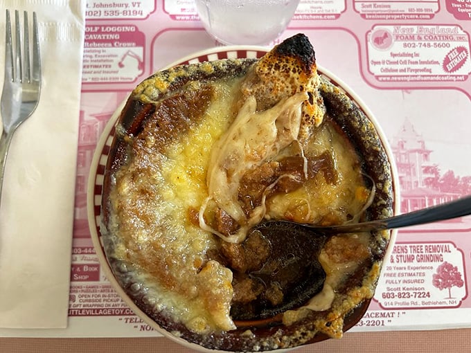 Bubbling cheese creating that perfect crown on French onion soup—the kind of simple perfection that makes you temporarily forget your table manners.