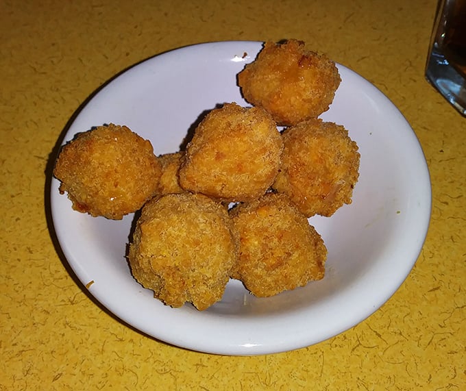 Golden-fried happiness in bite-sized form. These fritters aren't just appetizers; they're little spheres of joy worth fighting over.