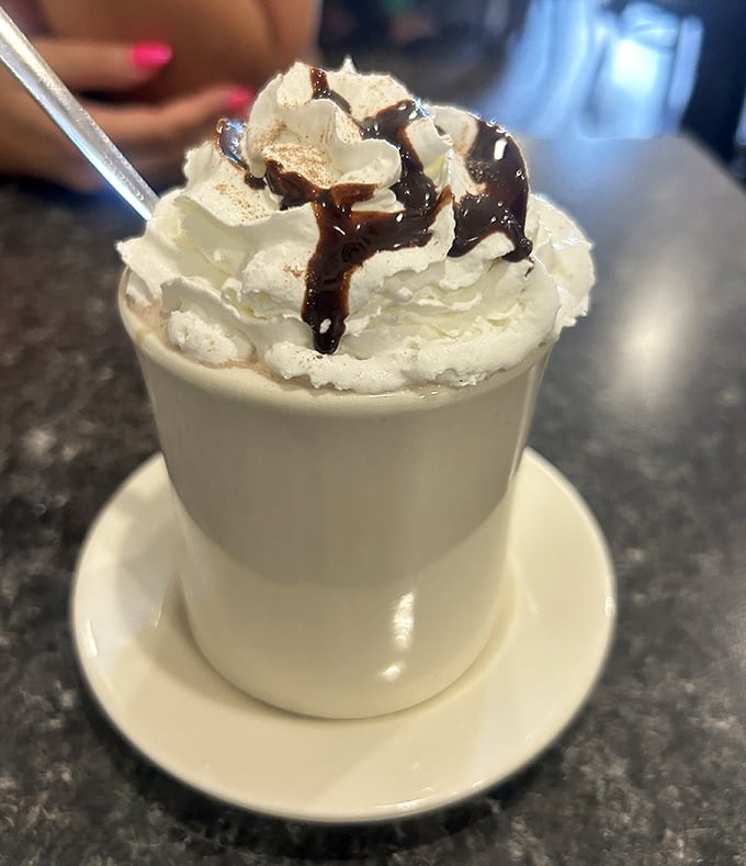 Hot chocolate that doesn't know it's not in a Swiss chalet. That mountain of whipped cream with chocolate drizzle is practically begging for an Instagram moment.