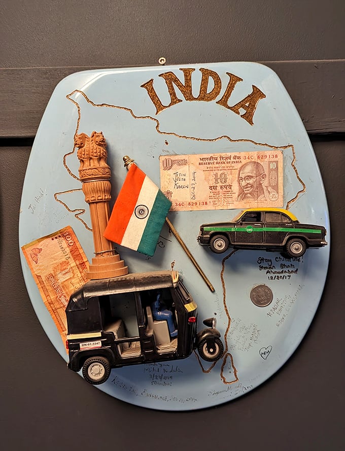 This India-themed seat features currency, miniature vehicles, and national symbols—a porcelain passport to the subcontinent.