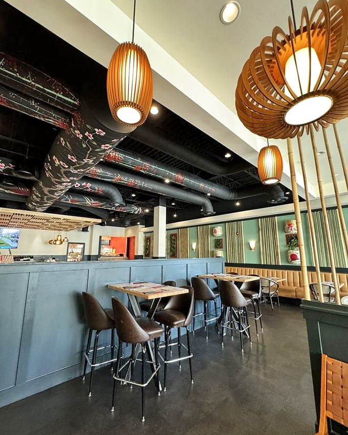 Wooden pendant lights hang like sophisticated cocoons, casting a warm glow that makes everyone look like they're in a glamorous food commercial.