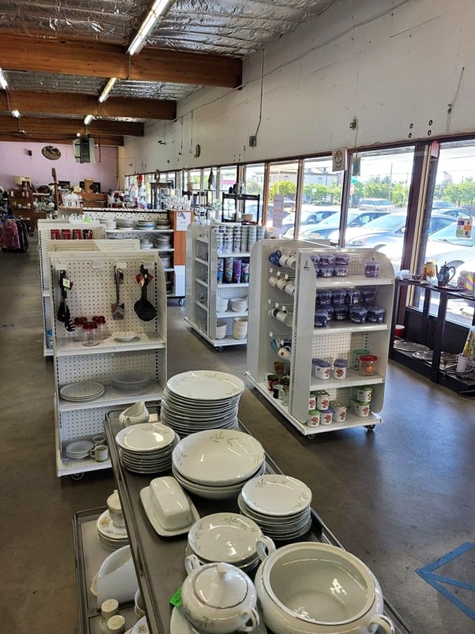 White dishes stacked like porcelain towers alongside practical kitchenware—the makings of countless future family dinners waiting to find new homes.