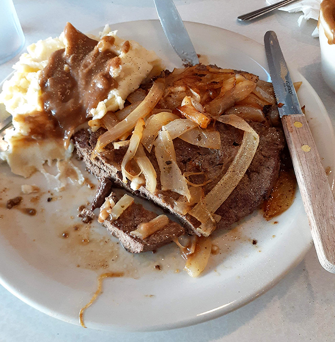 Liver and onions—the dish that separates casual diners from the true believers, smothered in caramelized onions and served with no apologies.