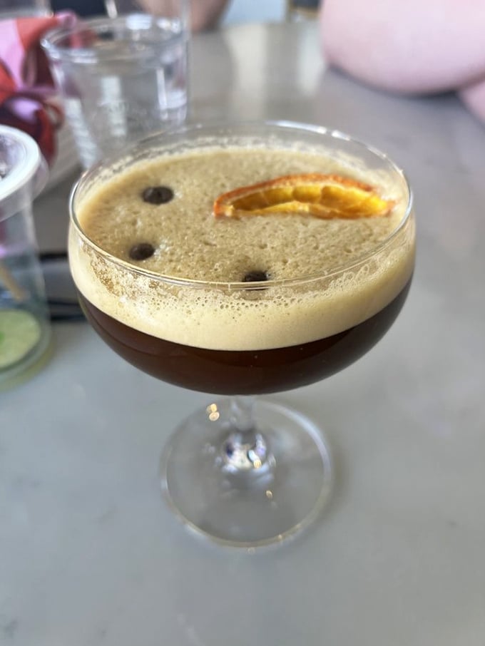This isn't just a cocktail—it's a work of art in a glass, with coffee beans floating like tiny islands in a sea of possibility.